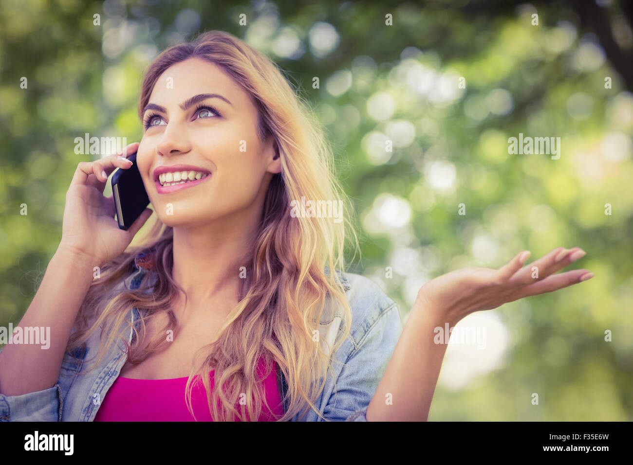 Smiling woman gesturing while using smartphone Stock Photo - Alamy