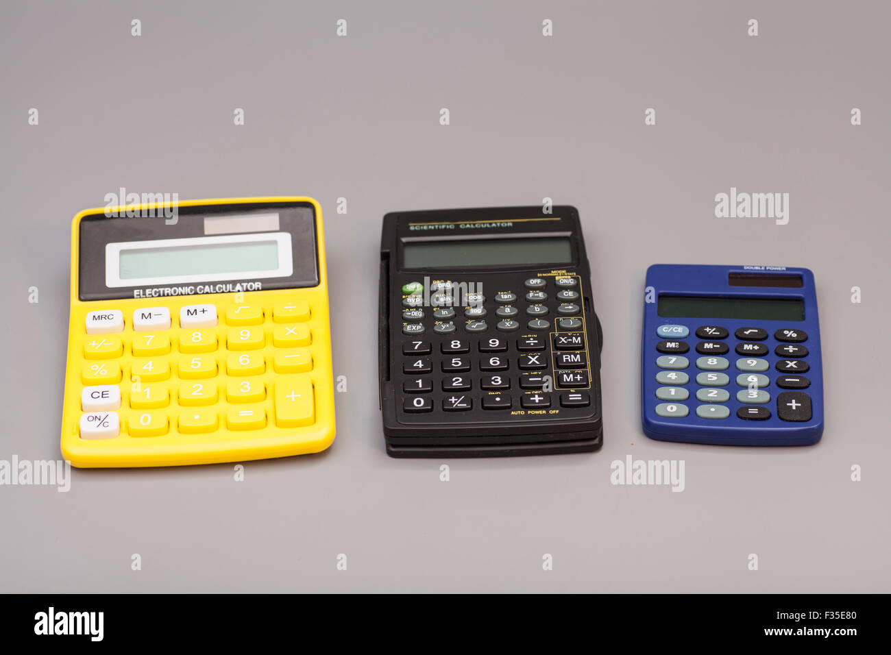three calculators isolated on gray background Stock Photo - Alamy