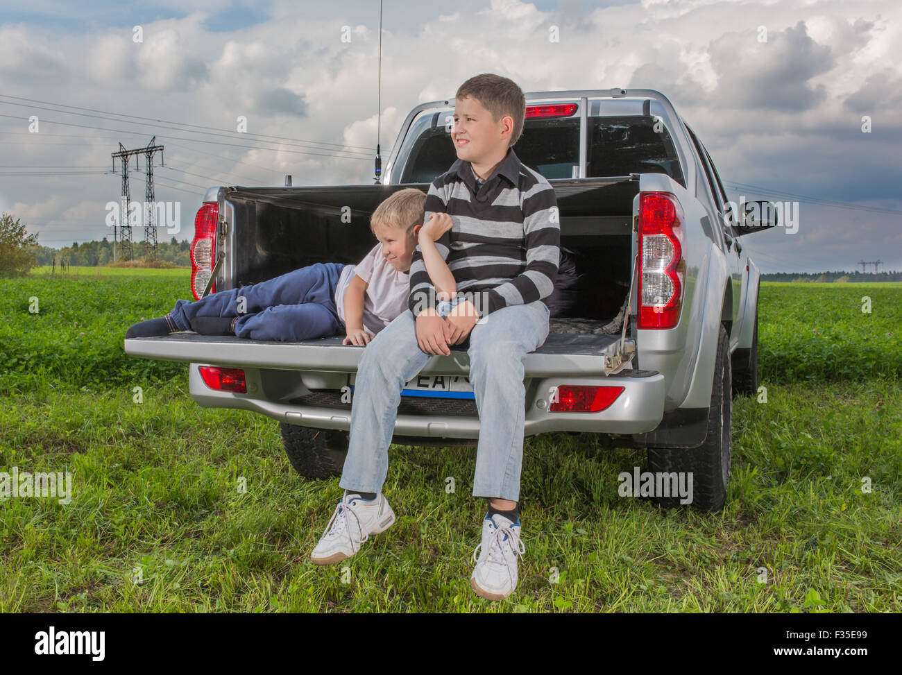 Two brothers siiting on a car trunk on natural background Stock Photo ...