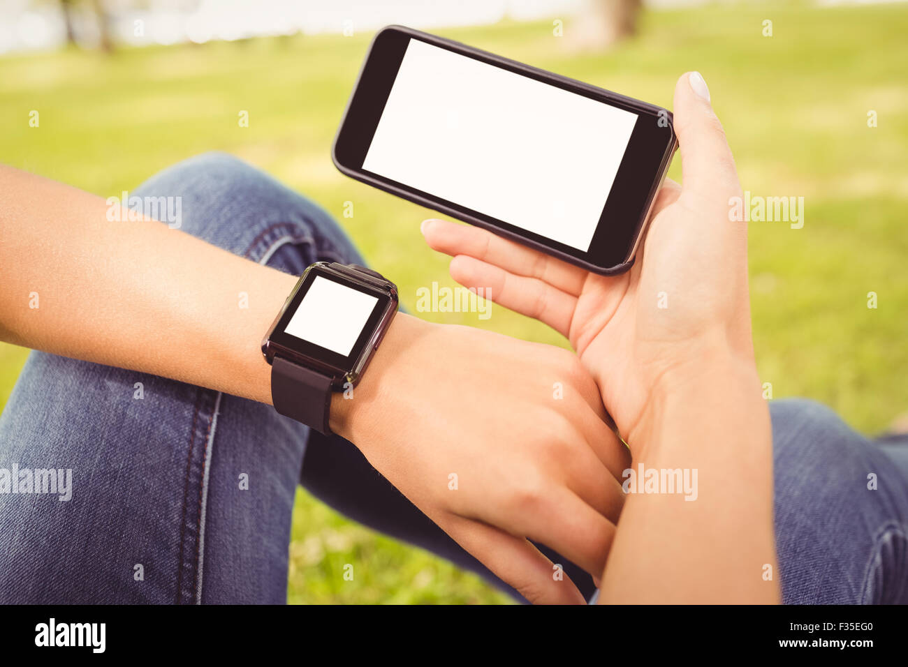 Low section of person wearing smart watch and holding smartphone Stock ...