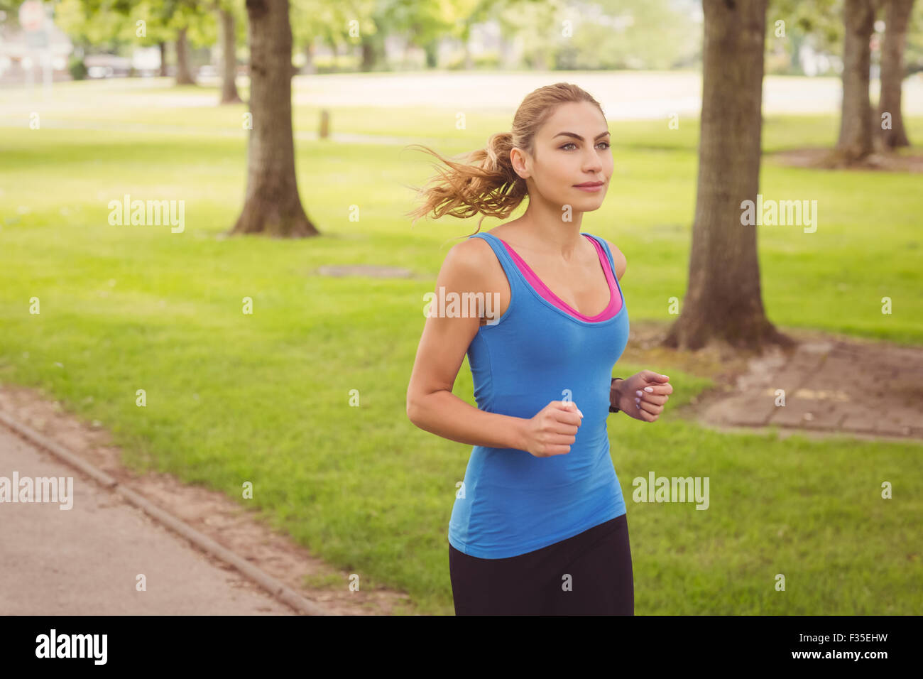 Confident woman running in park Stock Photo - Alamy