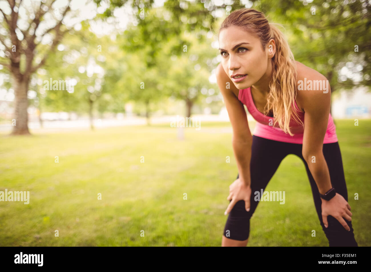 Woman bending in park Stock Photo - Alamy