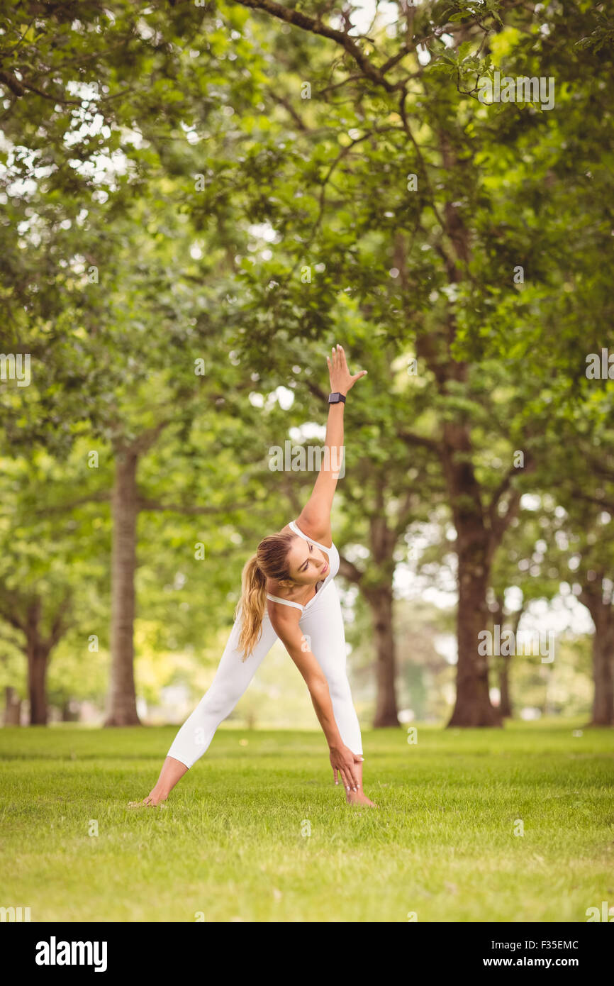 Full length of woman exercising while touching leg Stock Photo - Alamy