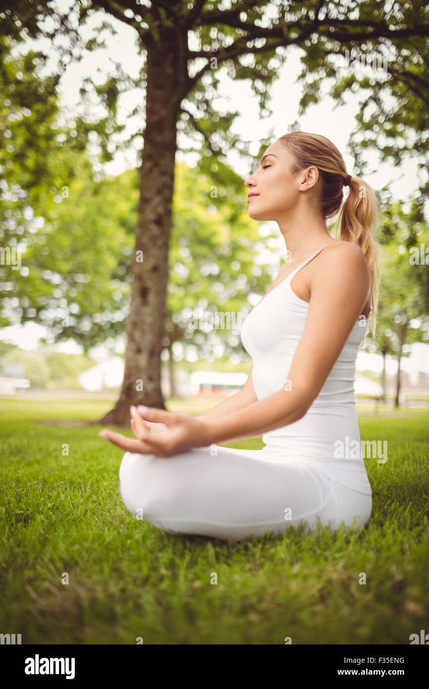 Side view of woman meditating while sitting in lotus pose Stock Photo ...