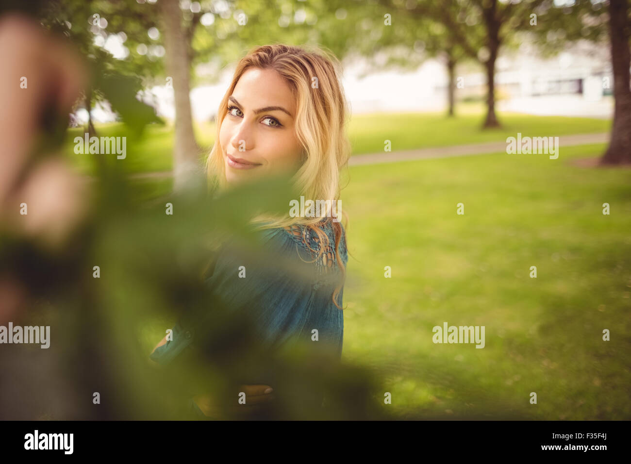 Portrait of beautiful woman standing by tree Stock Photo - Alamy