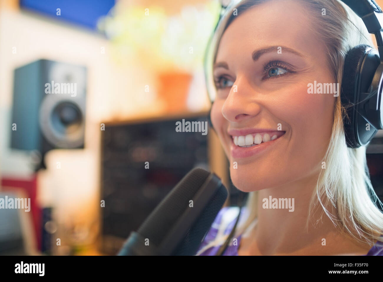 Young radio host wearing headphones using microphone studio Stock Photo ...
