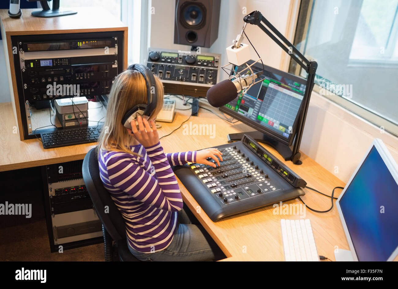Female radio host operating sound mixer Stock Photo - Alamy