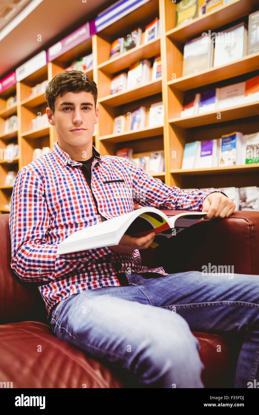Portrait of confident young man with book Stock Photo - Alamy