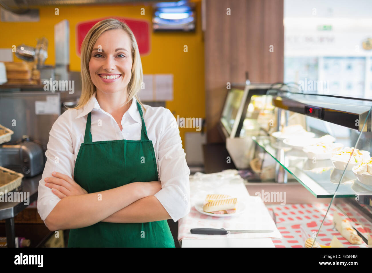 Confident female shop owner standing by display cabinet Stock Photo - Alamy