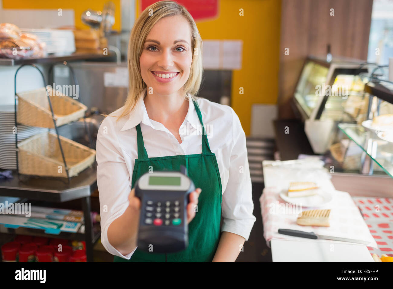 Happy female shop owner holding credit card reader Stock Photo - Alamy