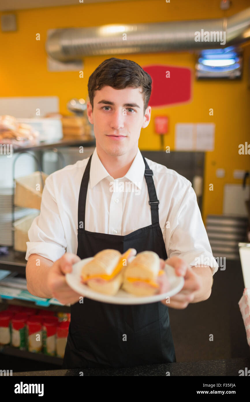 Confident male worker with sandwich in bakery Stock Photo - Alamy