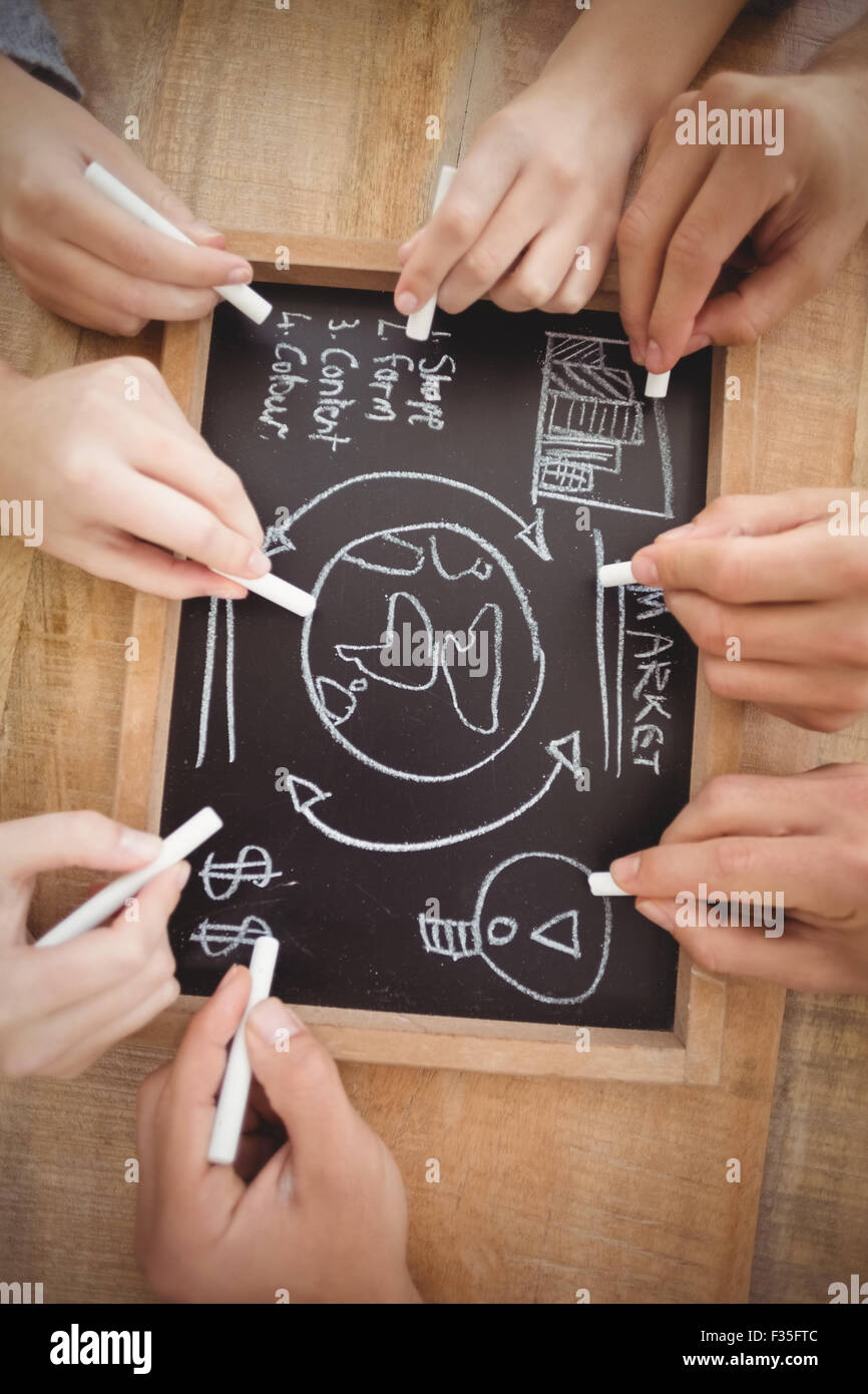 Overhead view of cropped hands writing business terms on slate Stock ...