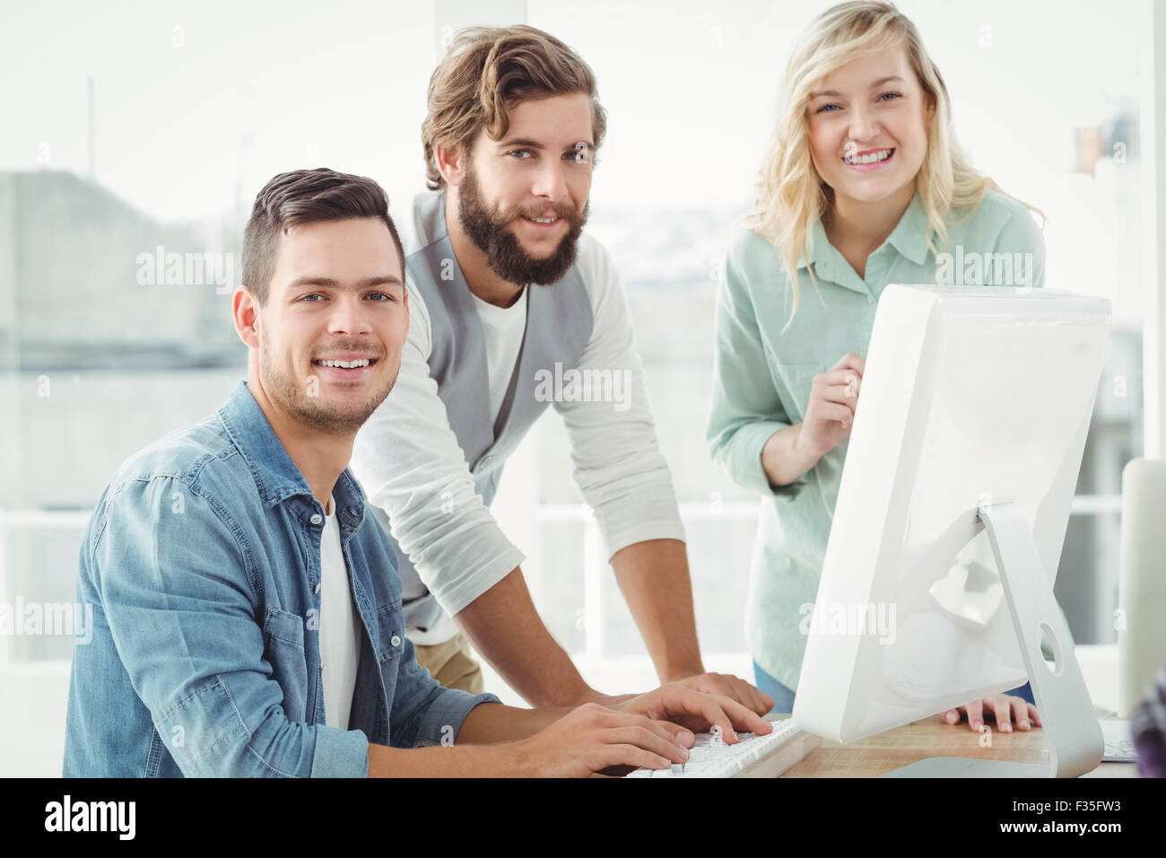 Professionals discussing at computer desk Stock Photo - Alamy