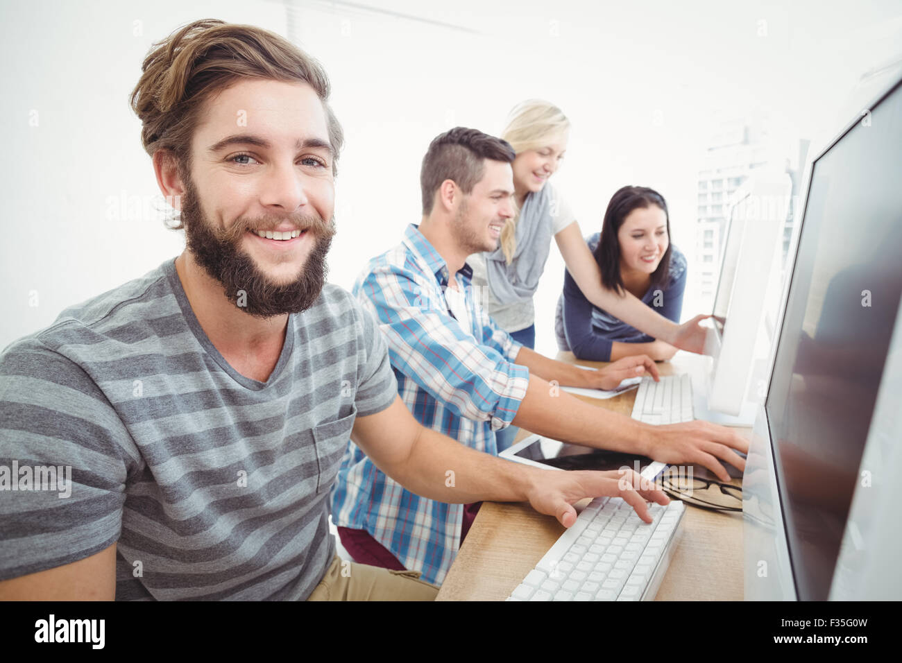 Portrait of cheerful businessman working at computer desk Stock Photo ...