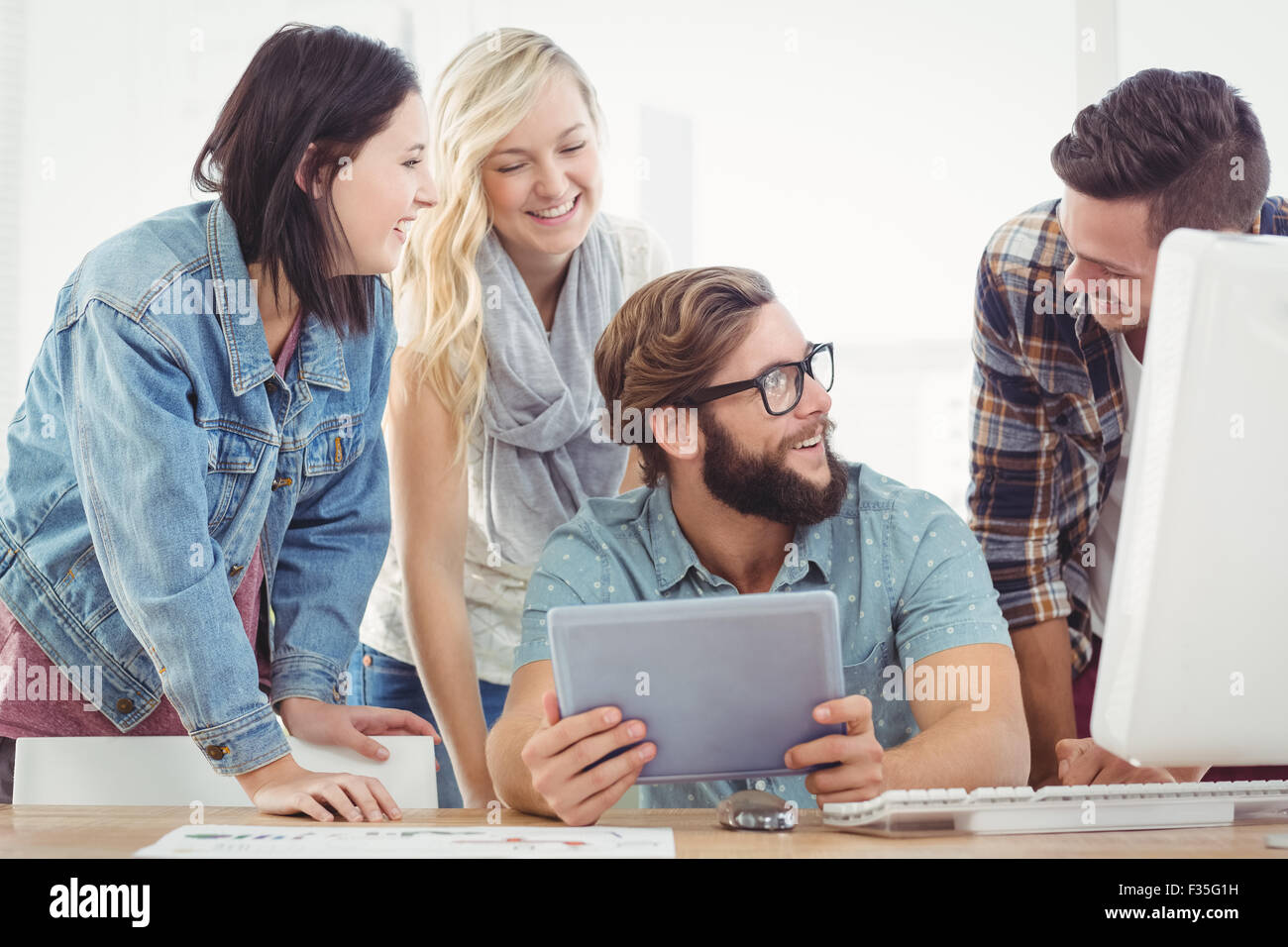 Happy business people using digital tablet at computer desk Stock Photo ...