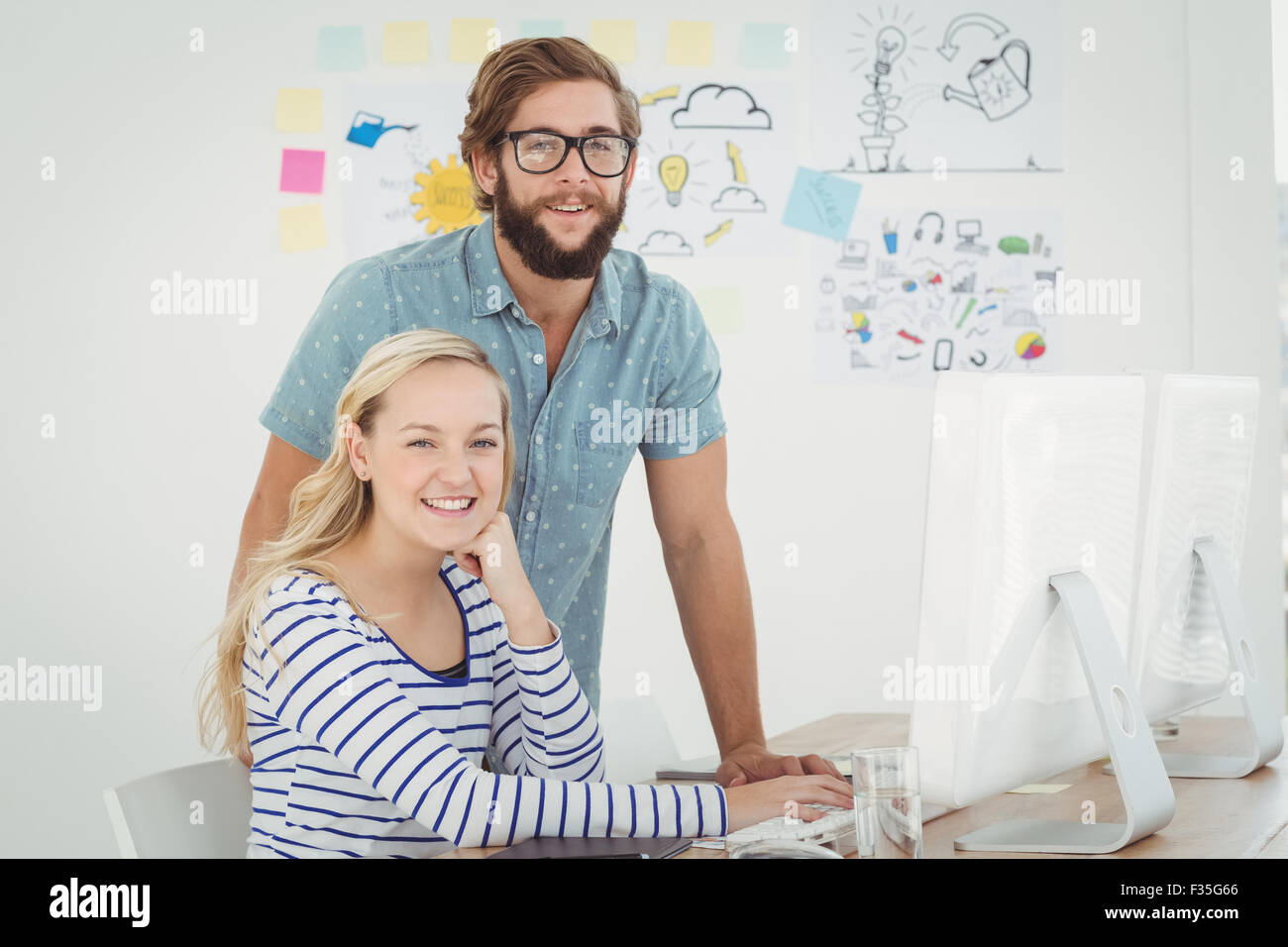 Portrait of smiling business people at computer desk Stock Photo - Alamy
