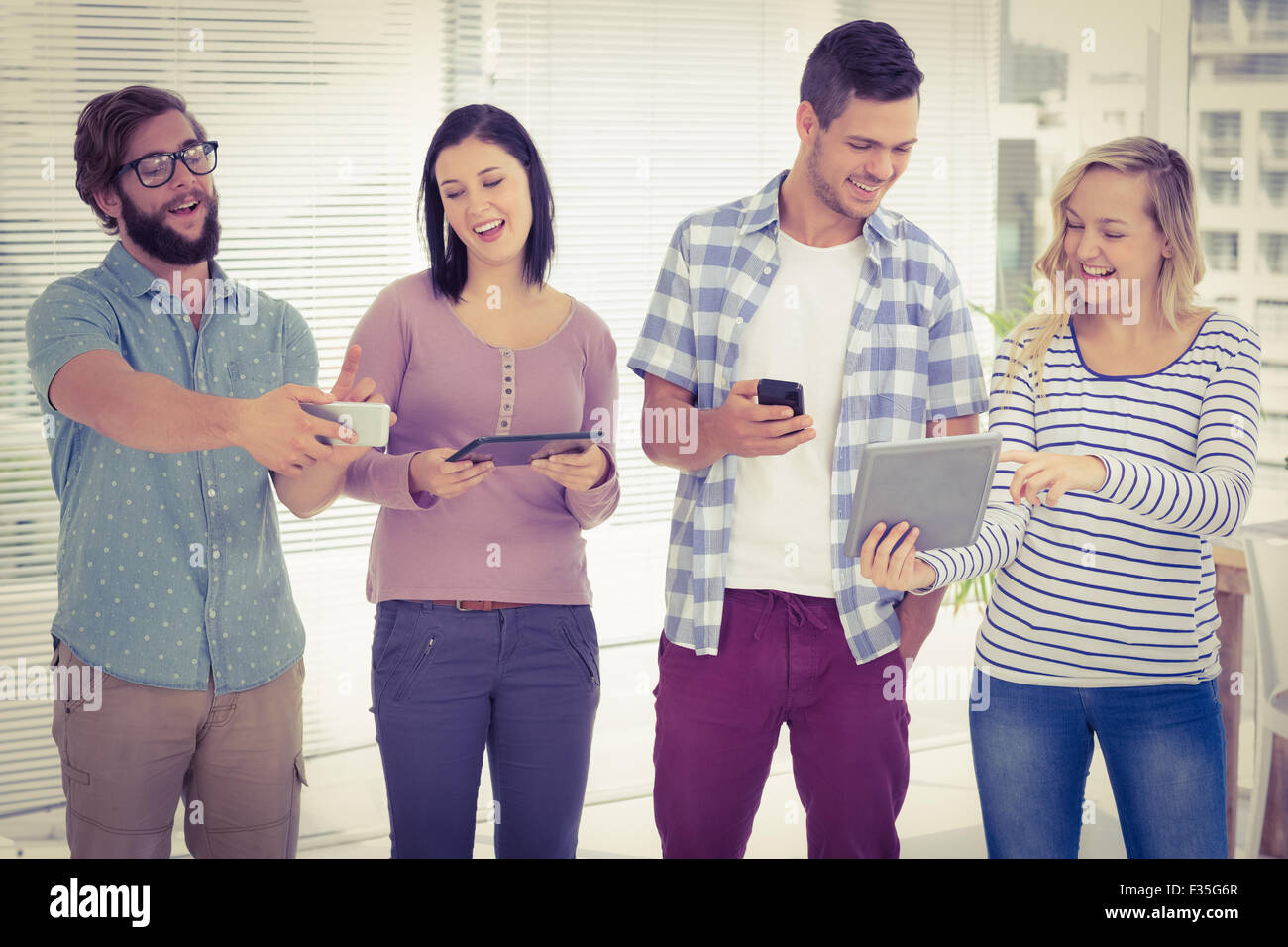 Happy business people using electronic gadgets Stock Photo - Alamy
