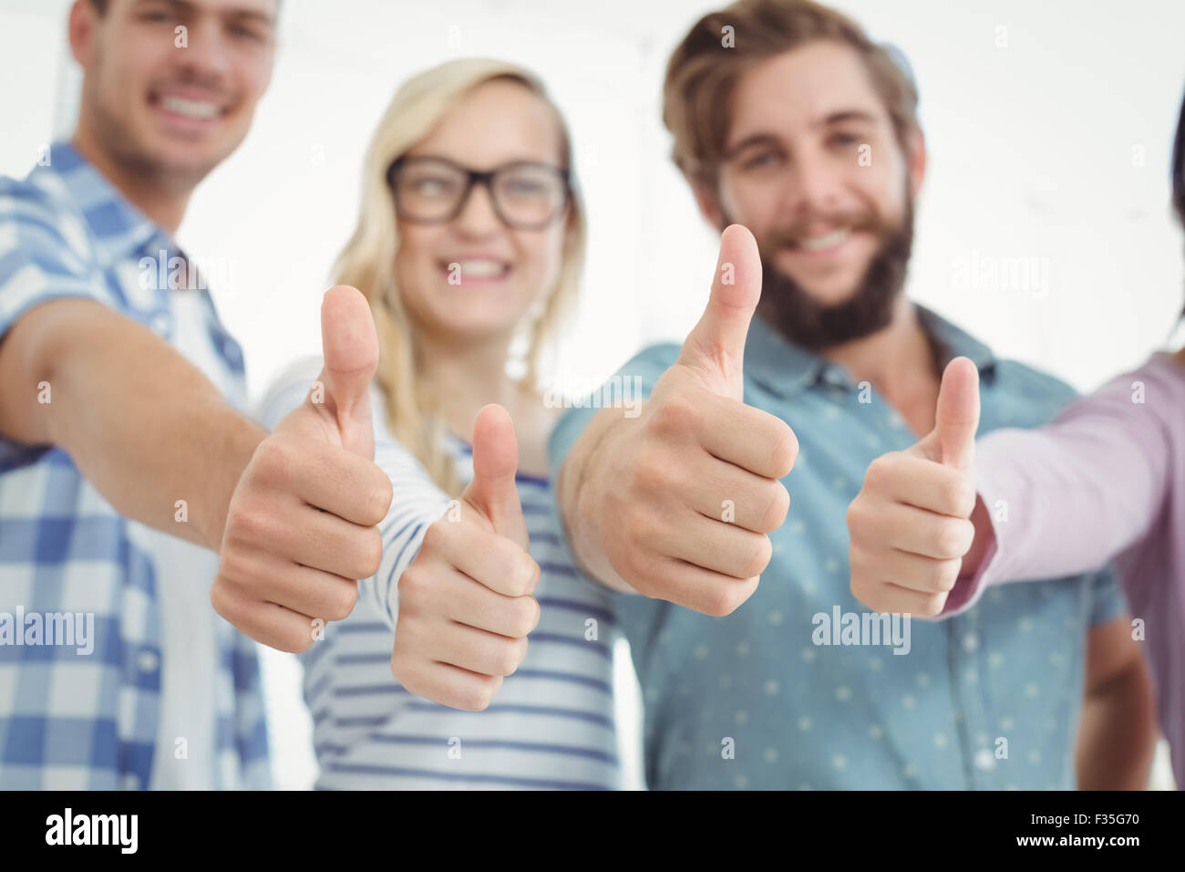 Smiling business people with thumbs up Stock Photo - Alamy