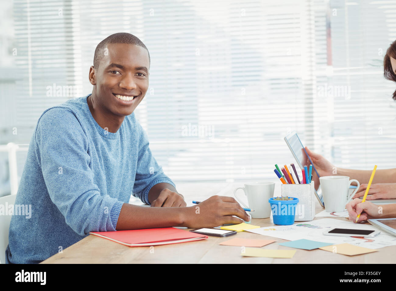 Portrait of smiling man while working at desk Stock Photo - Alamy