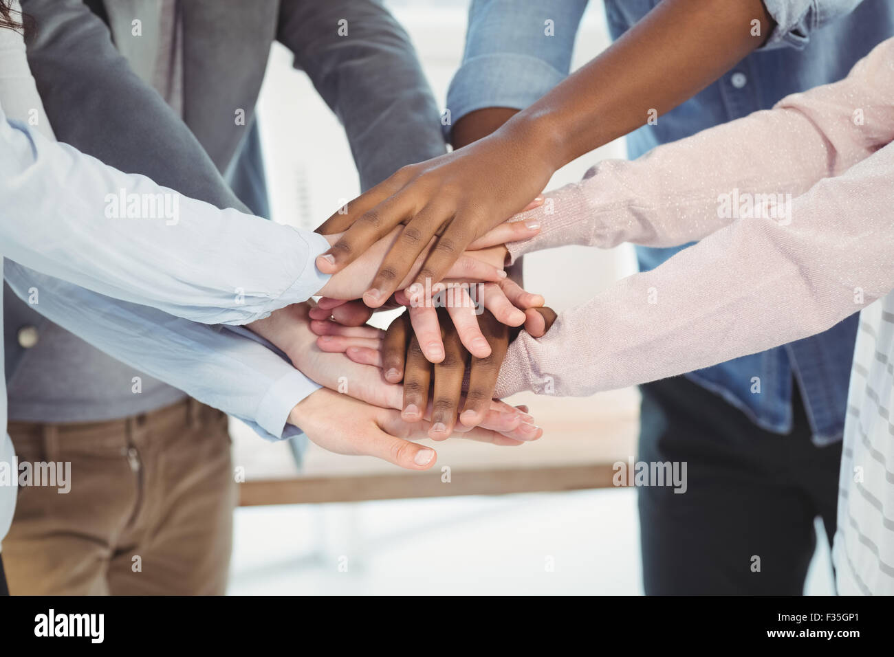 Mid section of business team putting their hands together Stock Photo ...