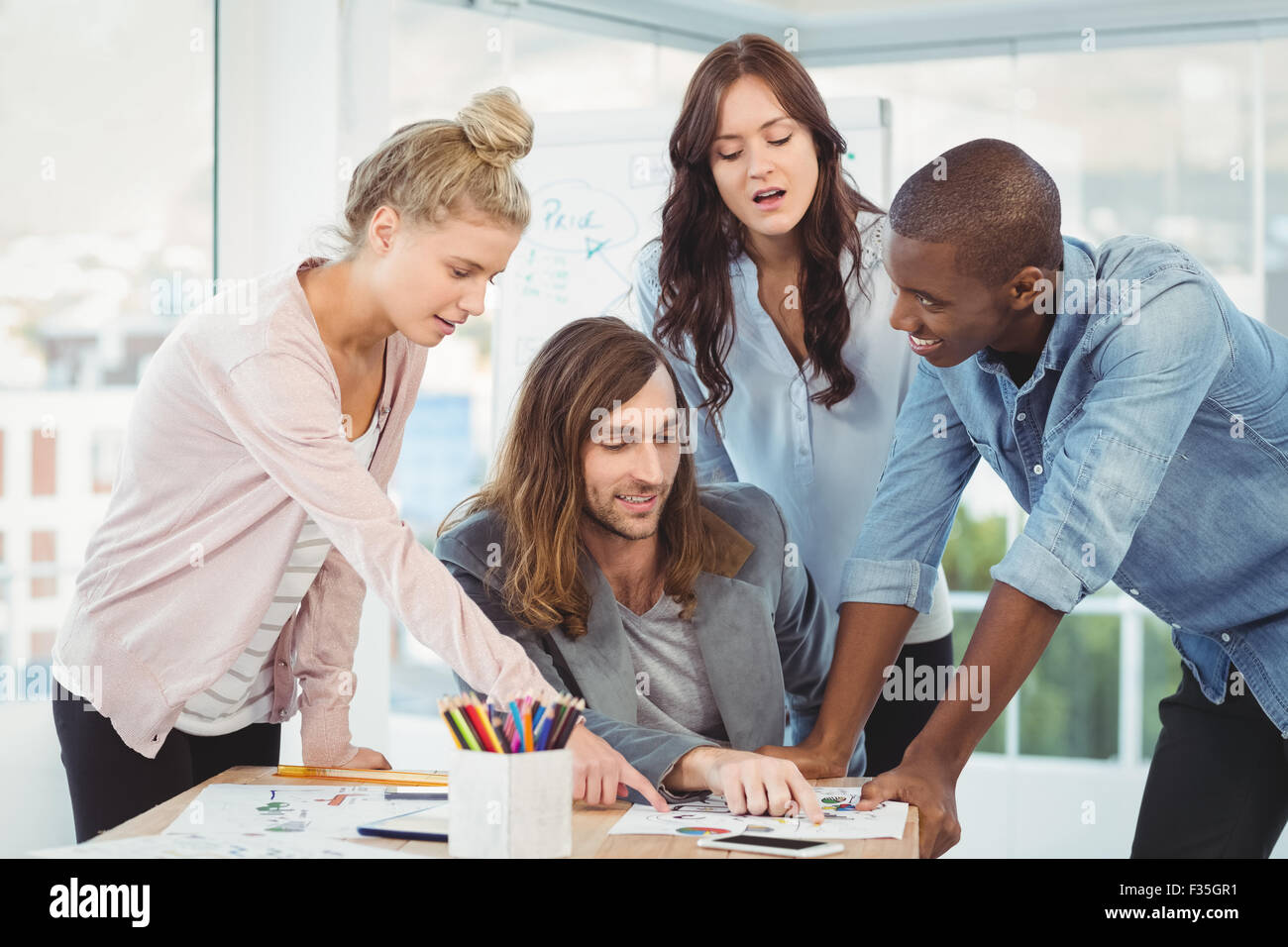 Business team discussing while pointing at diagram Stock Photo - Alamy