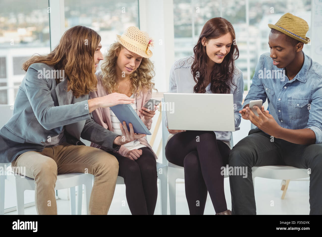 Business people using technology while discussing Stock Photo - Alamy
