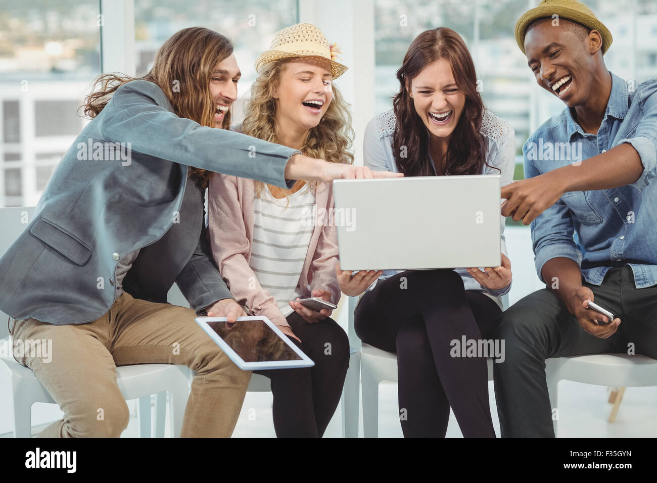 Business people laughing while pointing at laptop Stock Photo - Alamy
