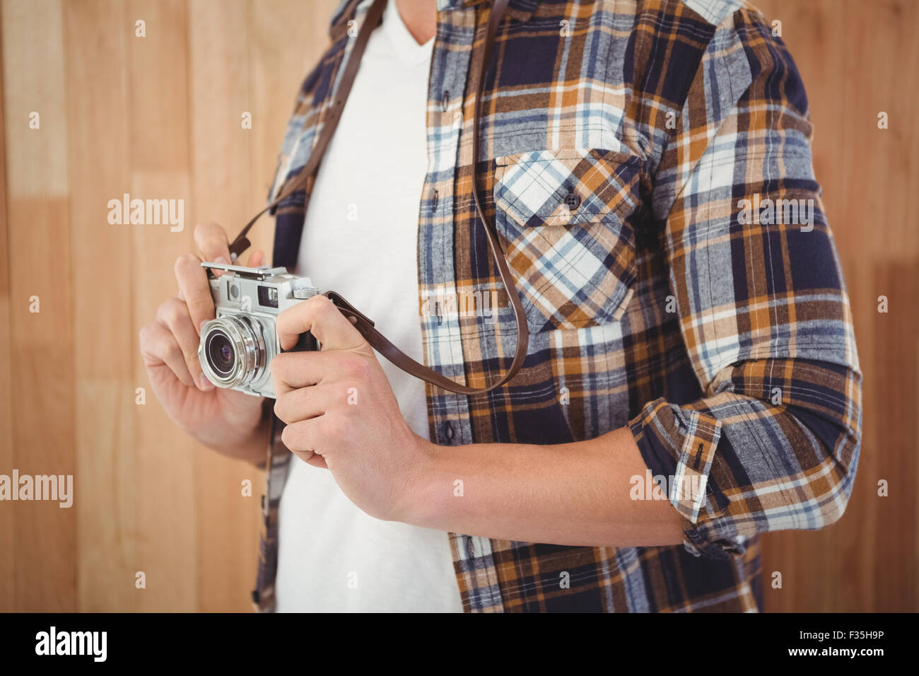 Mid section of hipster holding camera Stock Photo - Alamy