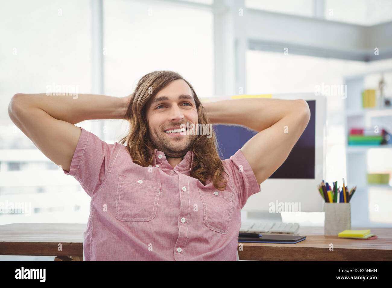 Happy man relaxing at computer desk Stock Photo - Alamy