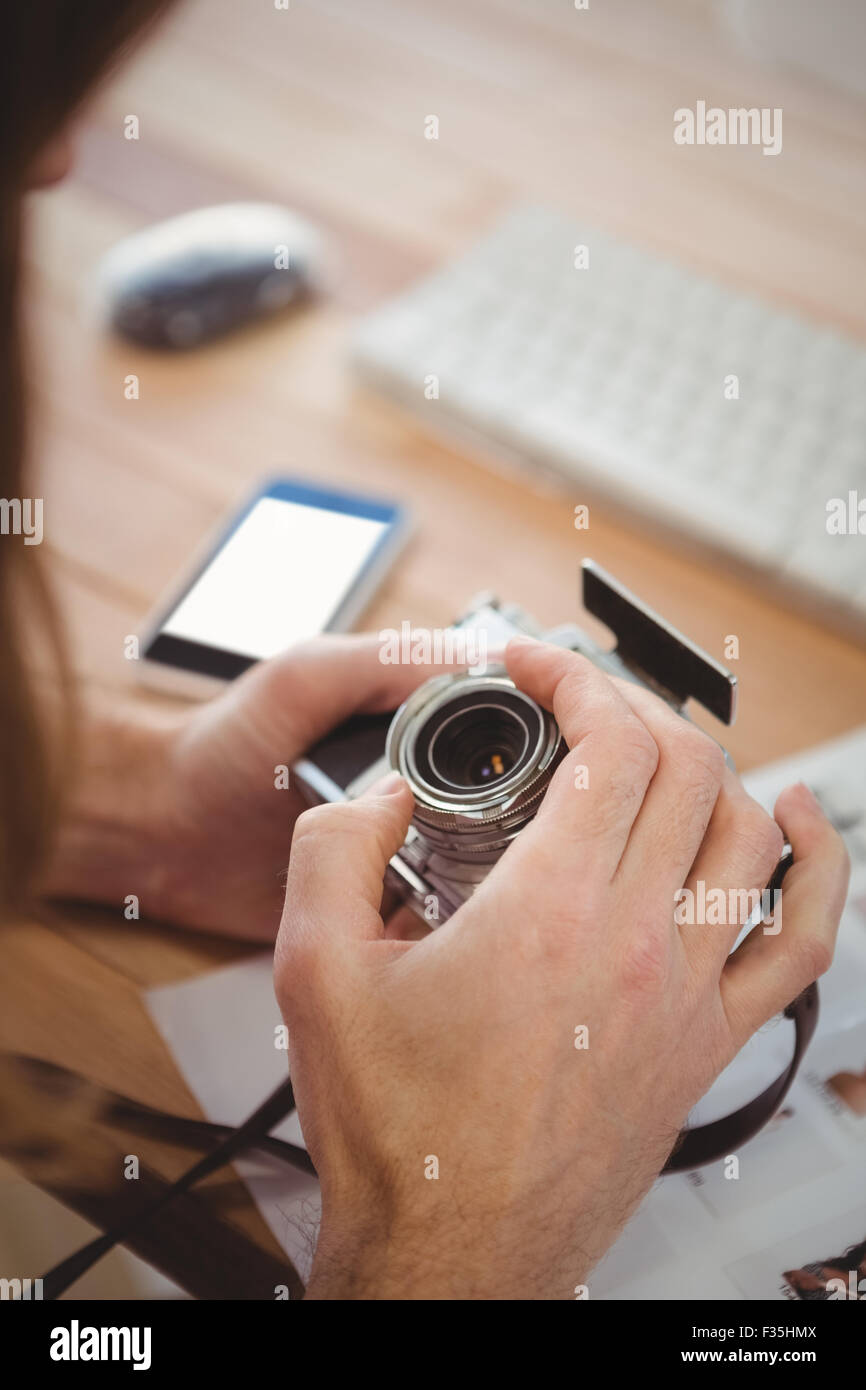 Cropped image of man adjusting camera lens at desk Stock Photo - Alamy