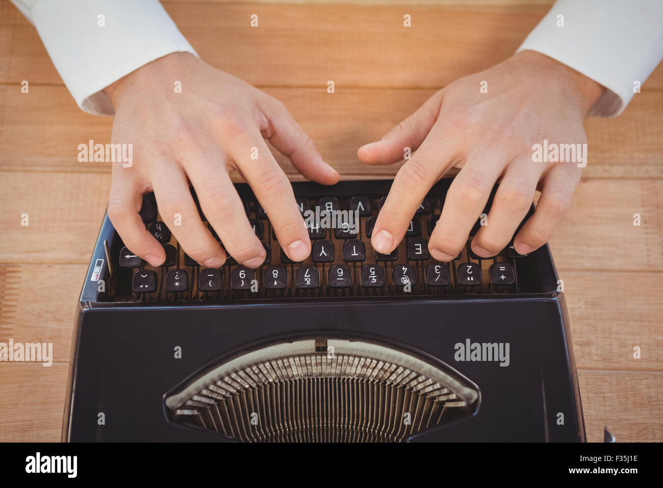 Man working on typewriter at table in office Stock Photo - Alamy