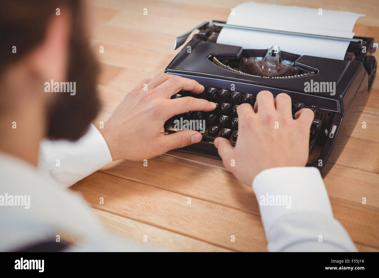 Man using typewriter at desk in office Stock Photo - Alamy