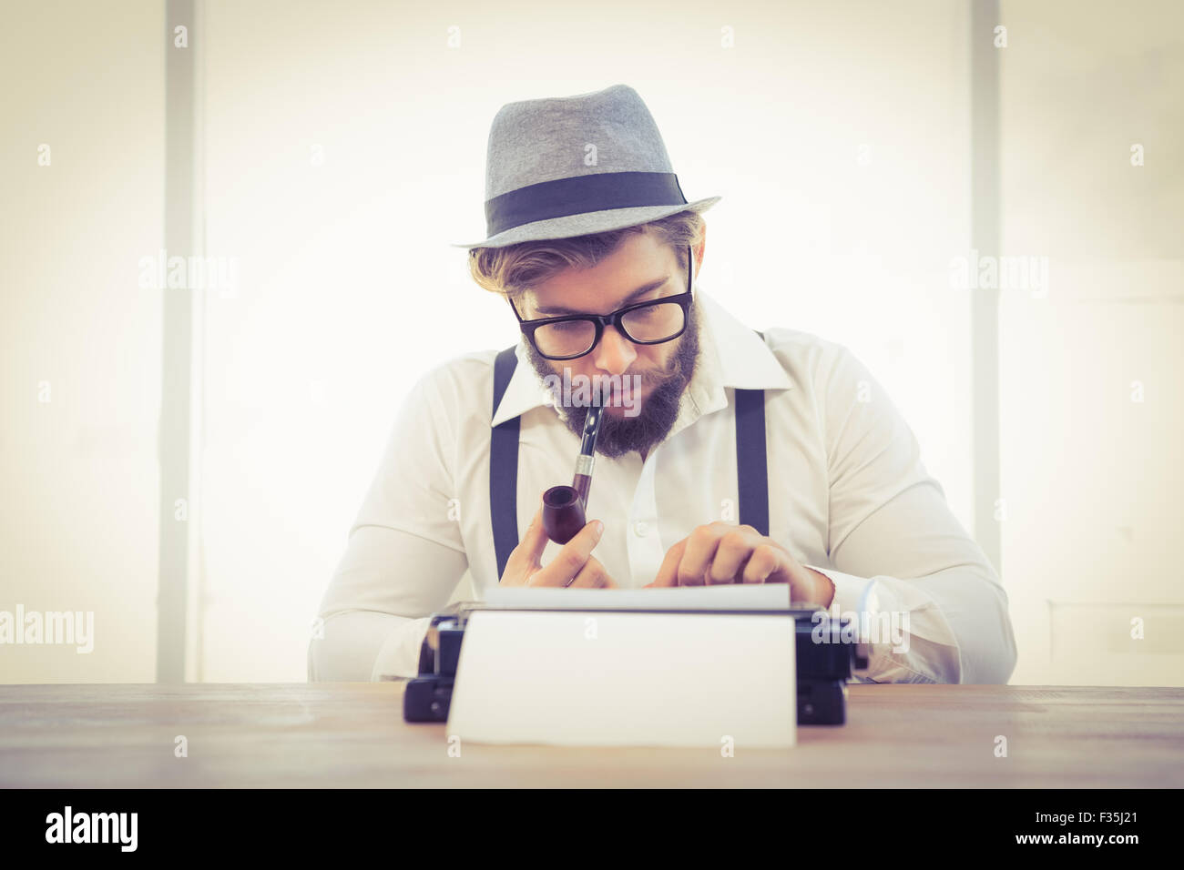 Hipster smoking pipe while working in office Stock Photo - Alamy