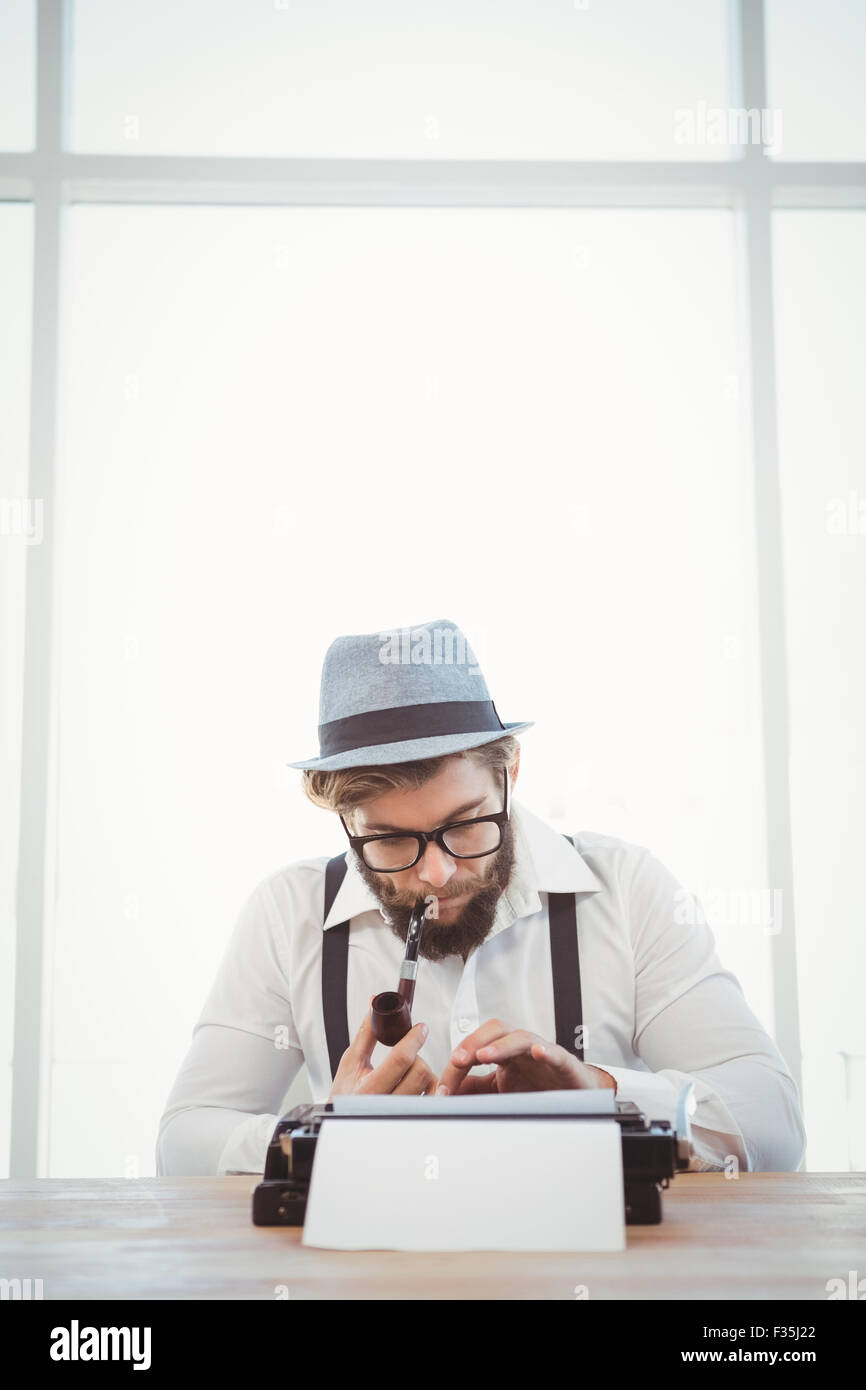 Hipster smoking pipe while working at desk Stock Photo - Alamy