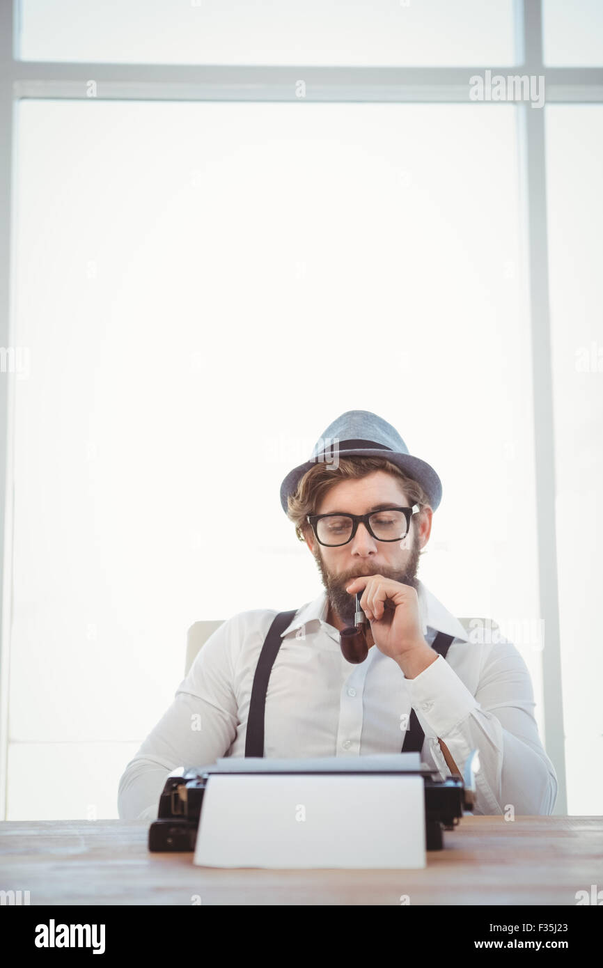 Hipster smoking pipe while sitting looking at typewriter Stock Photo ...