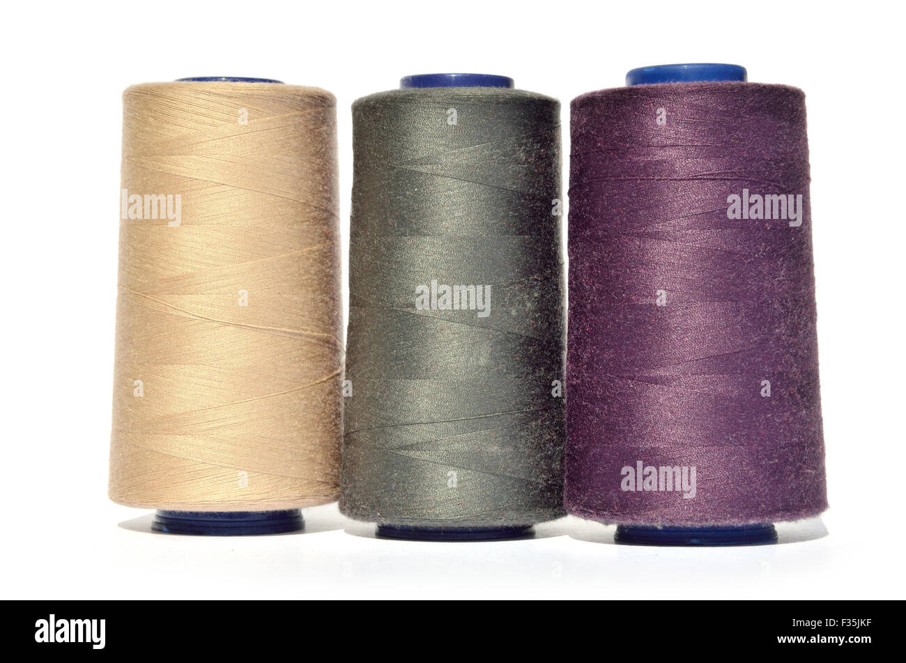 Reels of beige, grey and violet thread on white background Stock Photo ...