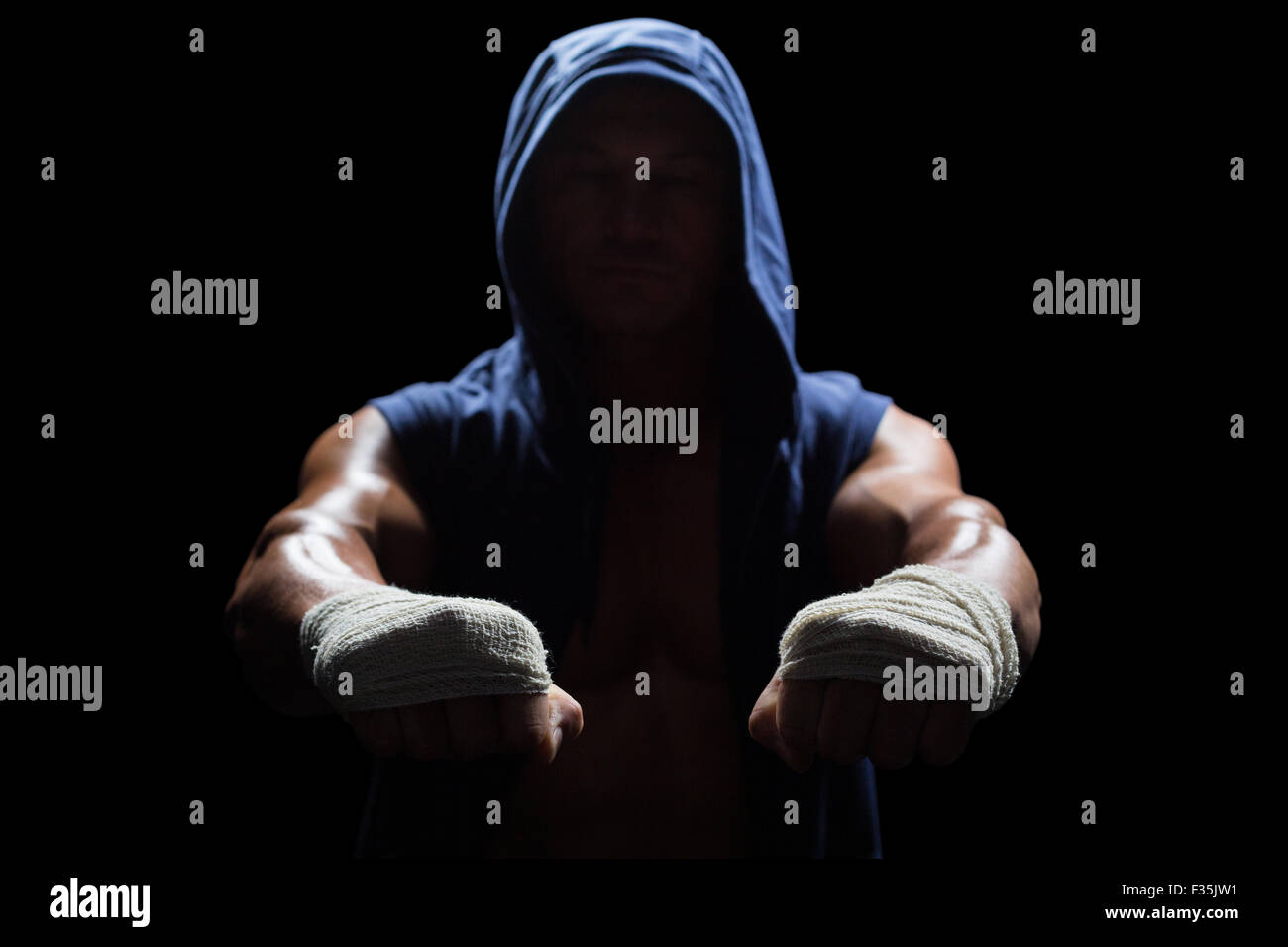 Muscular man in hood with bandage on hand Stock Photo - Alamy
