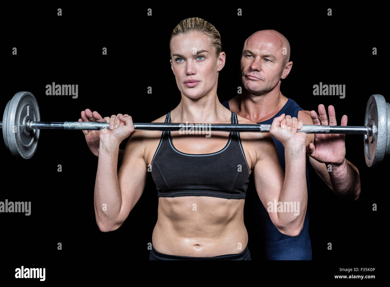 Trainer assisting woman for lifting crossfit Stock Photo - Alamy