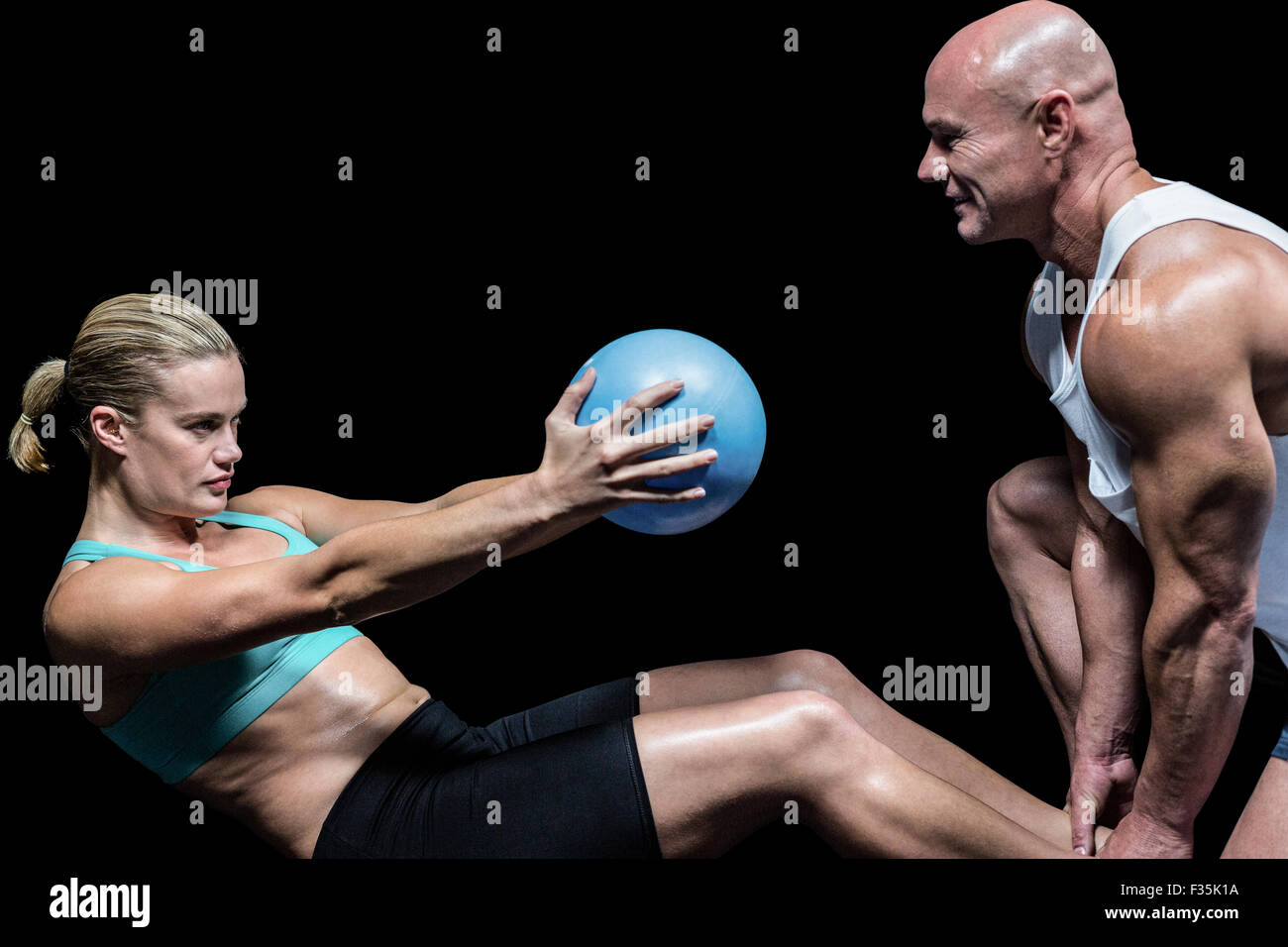 Trainer assisting woman doing crunching exercise Stock Photo - Alamy