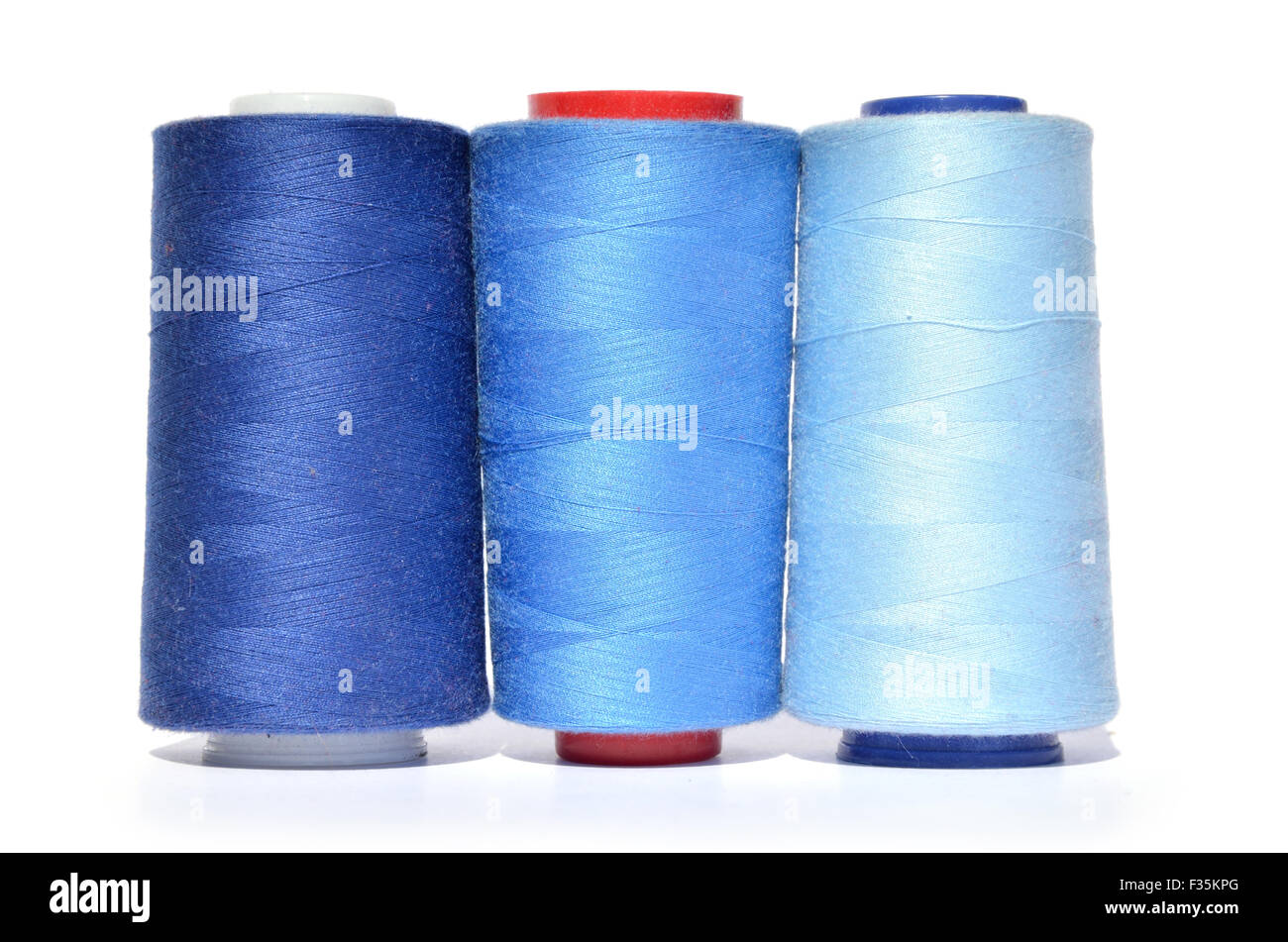 Reels of blue threads on white background Stock Photo - Alamy