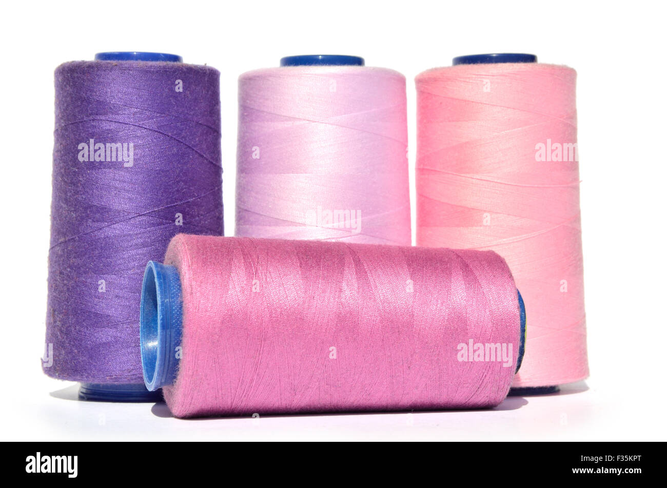 Reels of pink, violet and white thread on white background Stock Photo ...