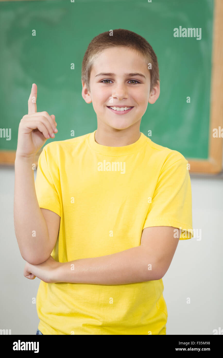 Smiling pupil raising hand in a classroom Stock Photo - Alamy