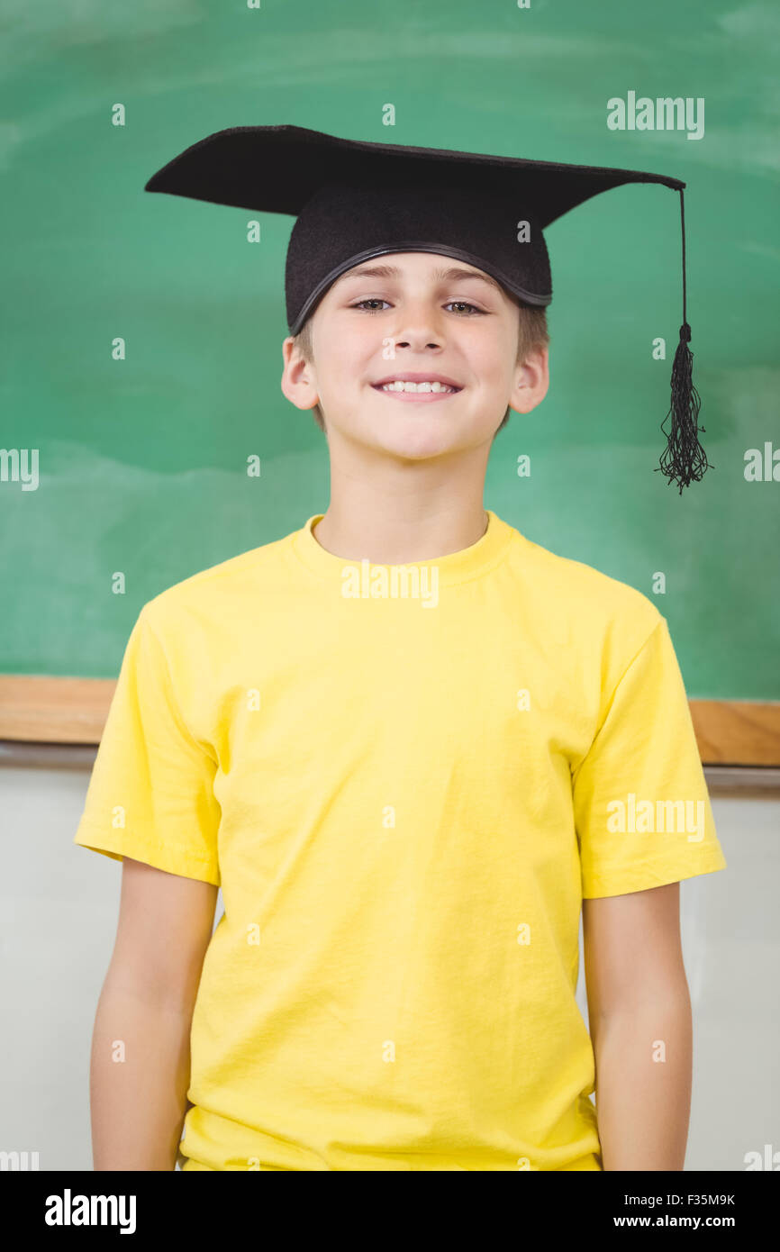 Smiling pupil with mortar board in a classroom Stock Photo - Alamy