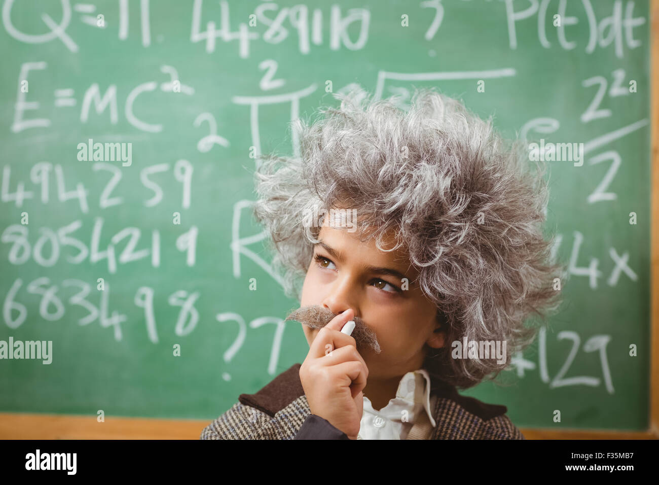Little Einstein thinking in front of chalkboard Stock Photo - Alamy