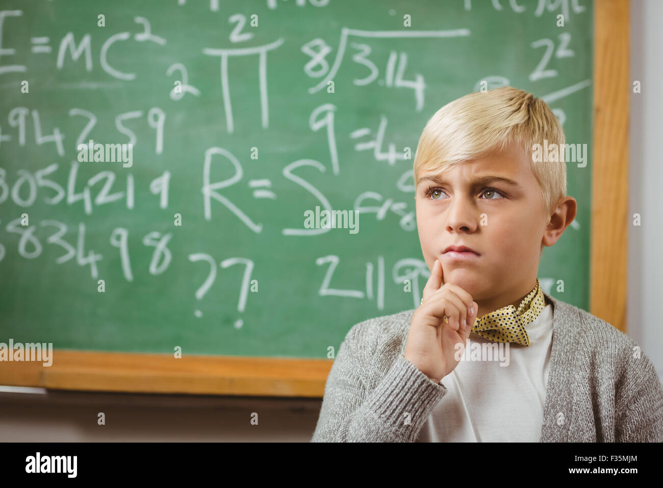 Pupil dressed up as teacher thinking in front of chalkboard Stock Photo ...