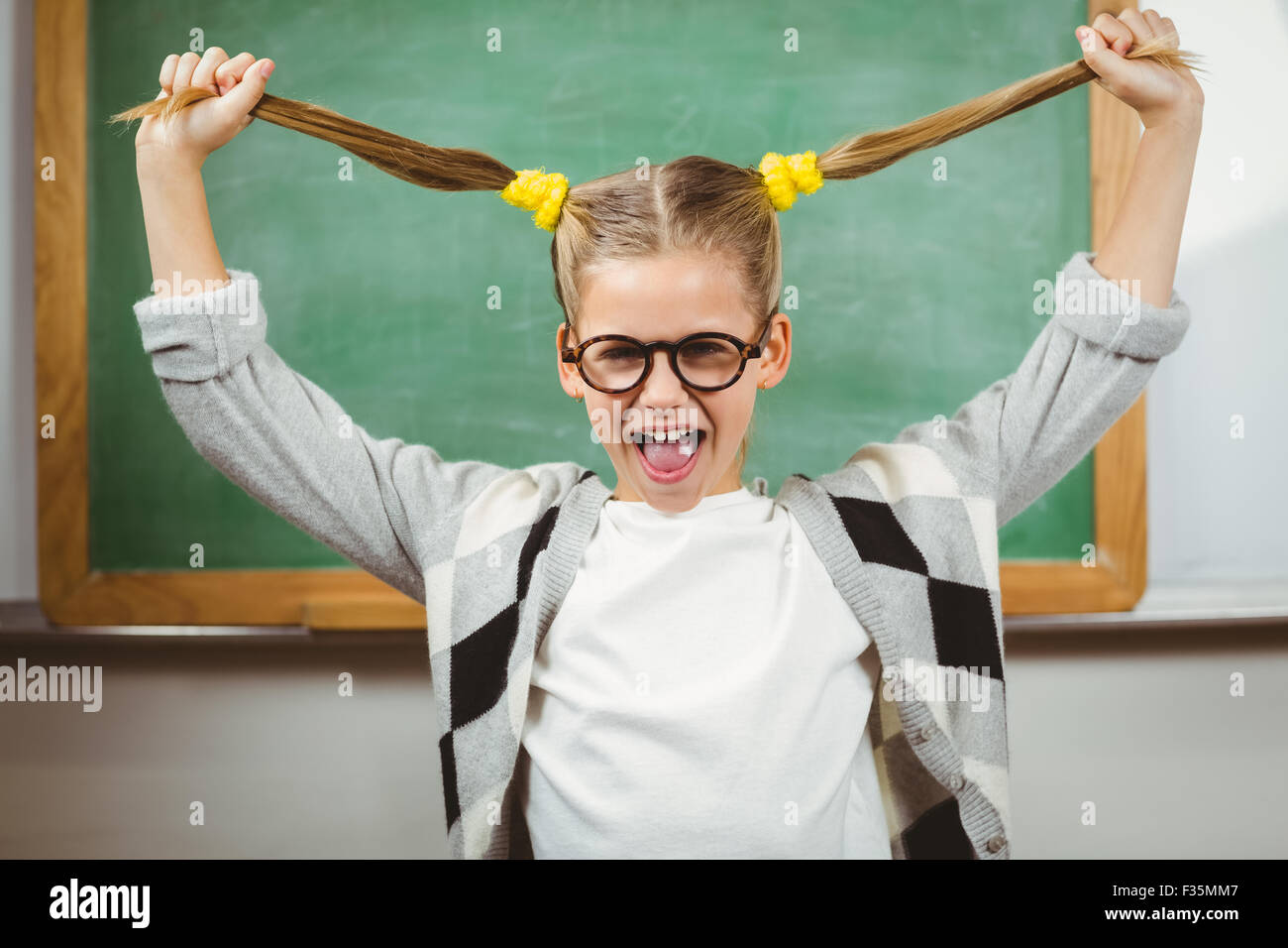Cute pupil pulling her hair in a classroom Stock Photo - Alamy