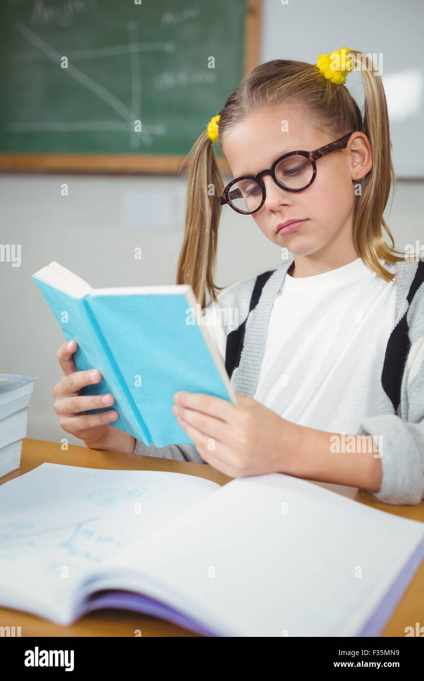 Concentrated pupil reading book at her desk Stock Photo - Alamy
