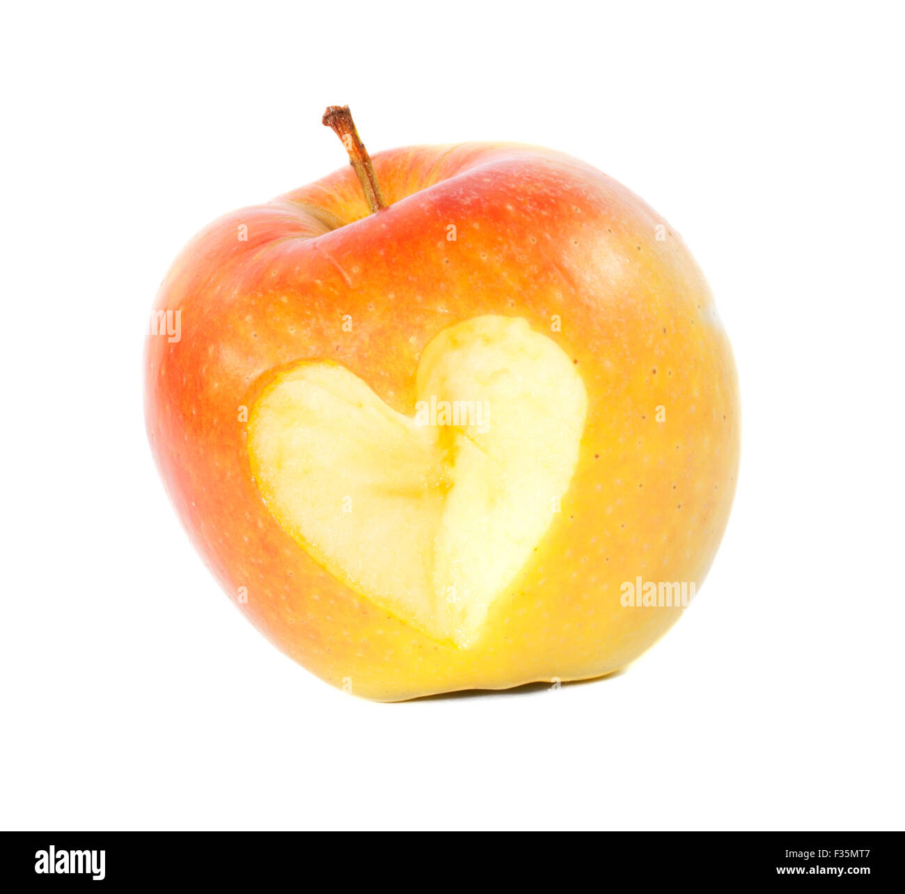 yellow apple with a carved heart isolated on white background Stock ...