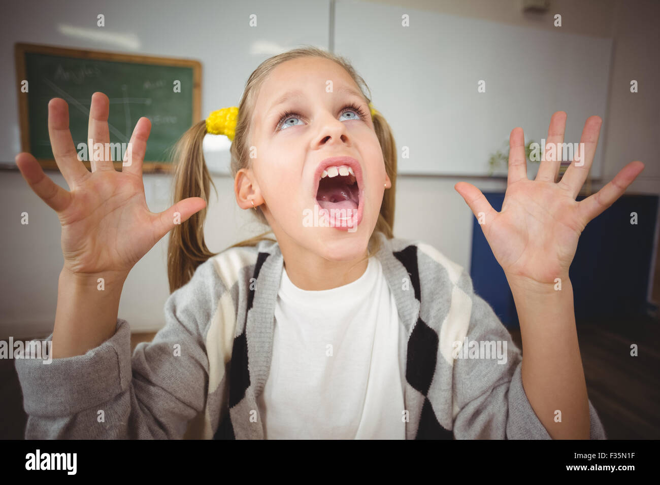 Shocked pupil sitting at her desk in a classroom Stock Photo - Alamy