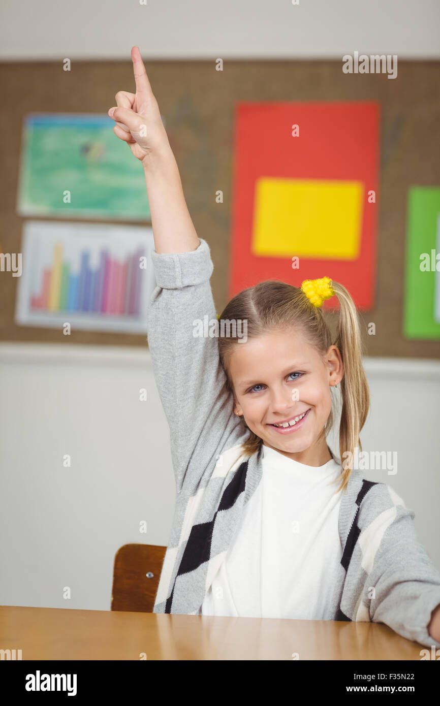 Cute pupil raising hand in a classroom Stock Photo - Alamy
